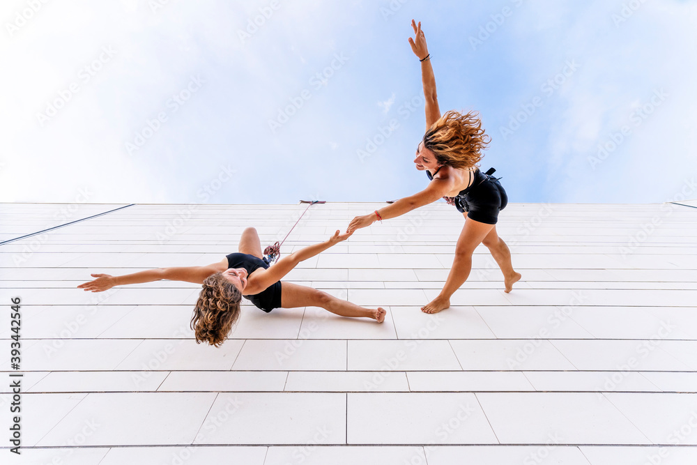 Aerial dancers holding hands and hand raised dancing on window Stock ...