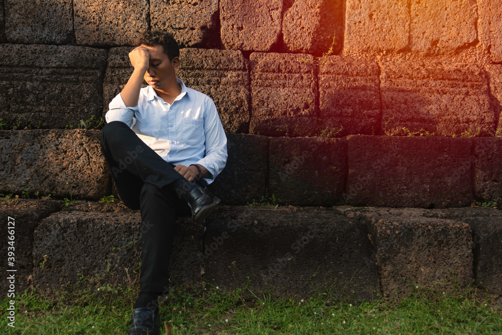 Foto de Asia you man sitting alone.He sitting alone beside old wall.man very sad and depressed ...