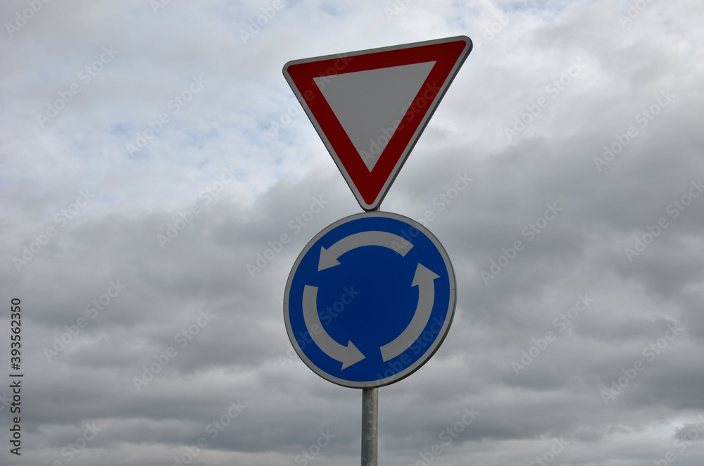 roundabout traffic signs with an e-sign give priority to driving cars ...