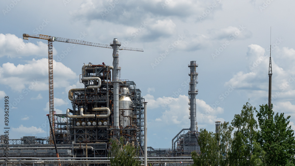 Distillation tower or column on blue sky with clouds background. Oil ...
