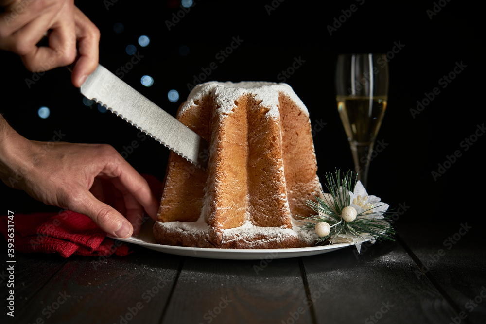 Cutting a slice of Pandoro, a typical Italian Christmas cake. The cake ...
