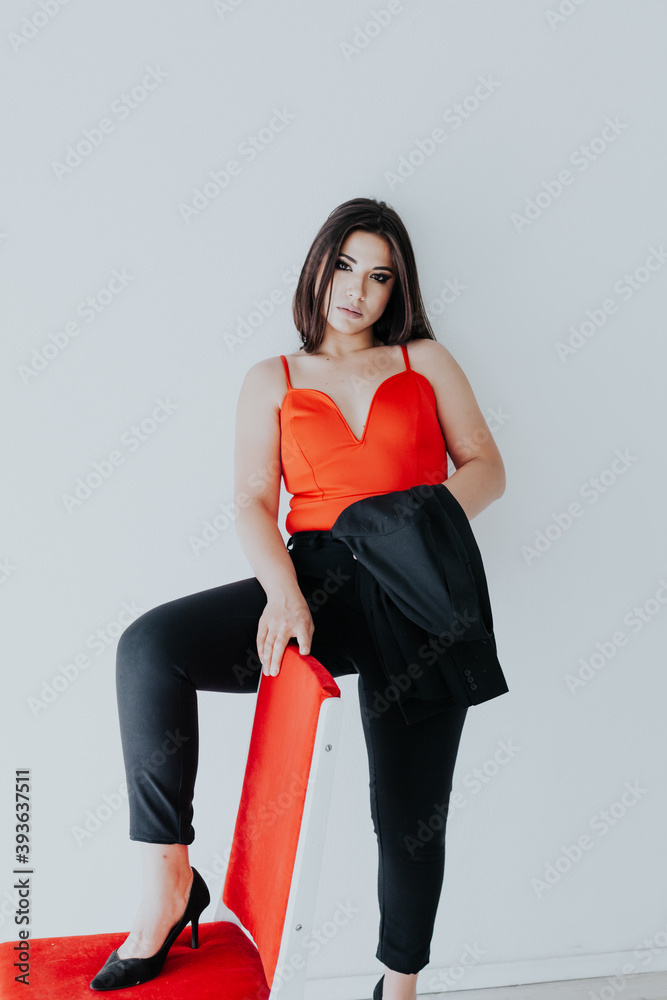 Beautiful brunette woman in red black business clothes at work in white ...