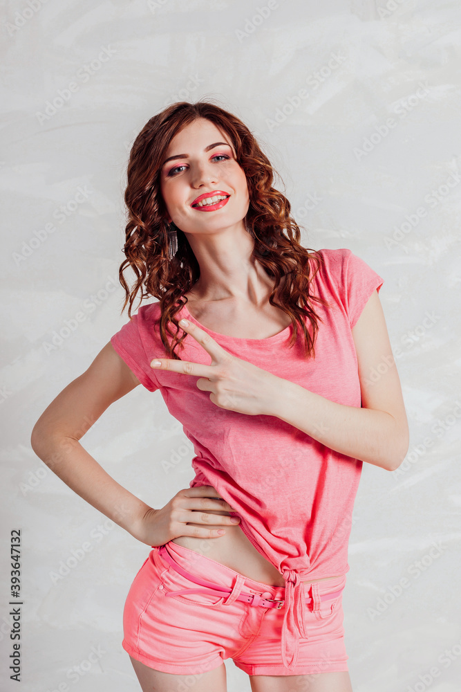 Beautiful pin up woman in pink shows two fingers Stock Photo | Adobe Stock