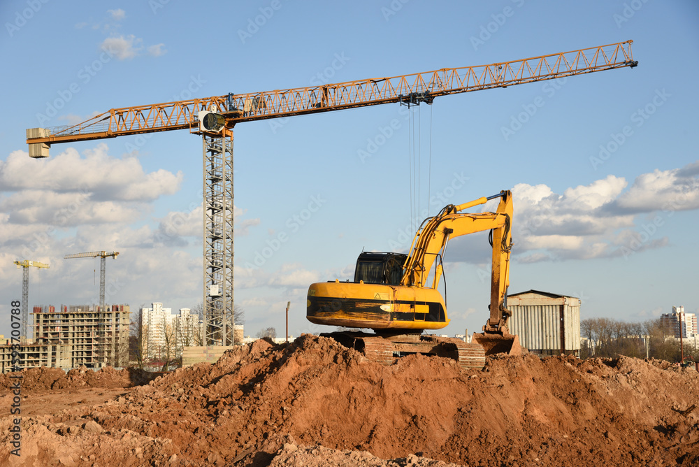 Excavator during earthmoving at construction site. Backhoe dig ground ...