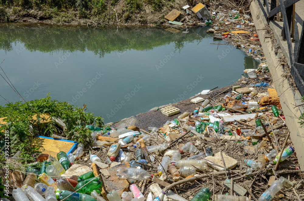 Plastic bags, bottles, garbage and trash dumped in river in nature ...