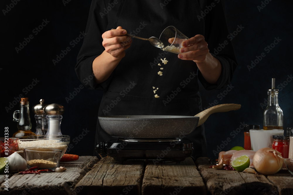 Professional chef pours rice into pan with chicken fillet. Backstage of ...