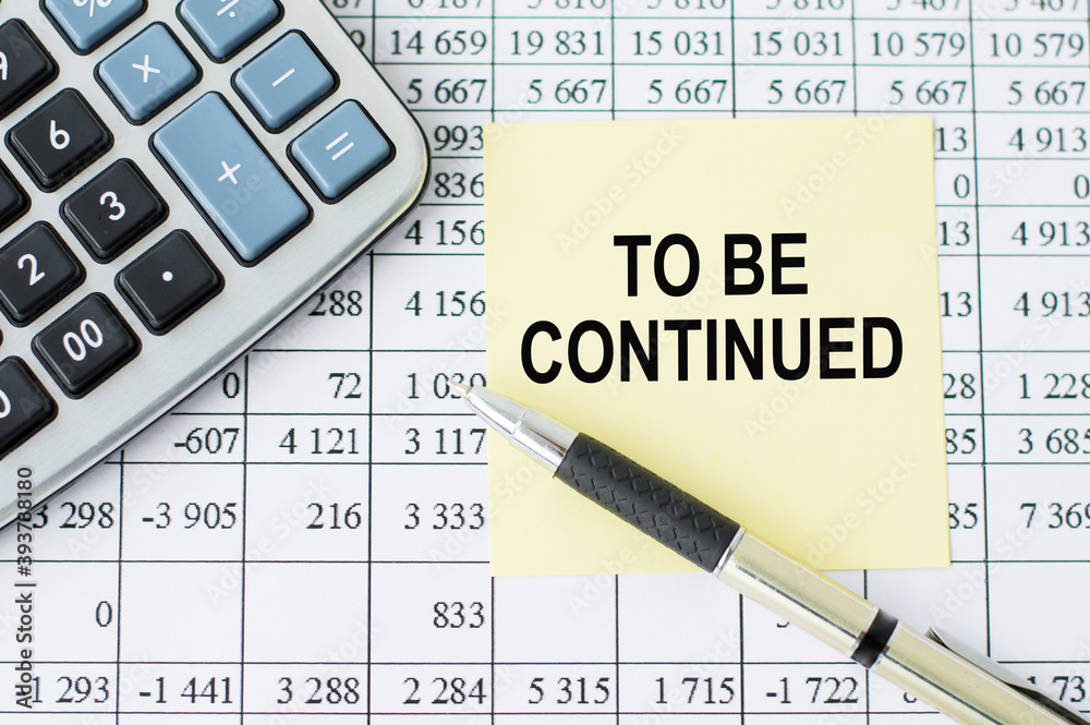 on a desk calculator, pen and note paper with text TO BE CONTINUED on ...