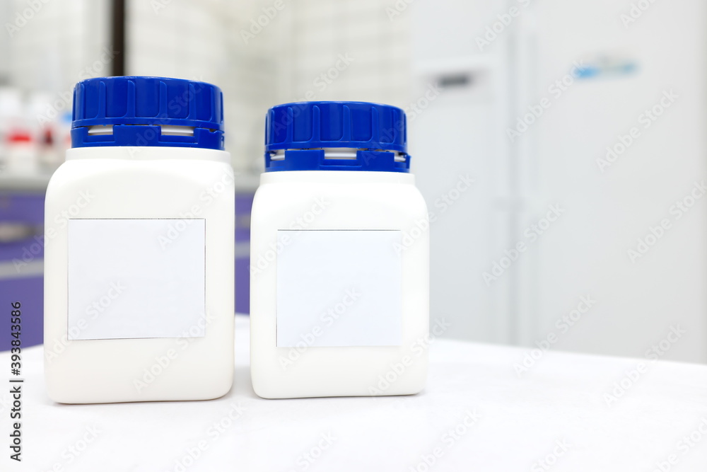 Two unlabeled plastic chemical bottle container with cap in a white ...