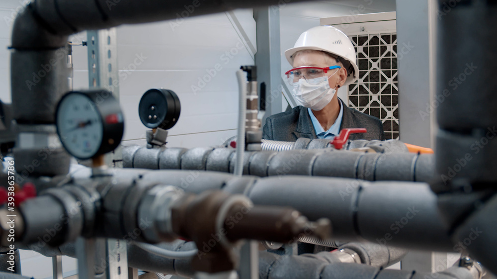 Maintenance engineer in safety mask checking technical data of heating ...