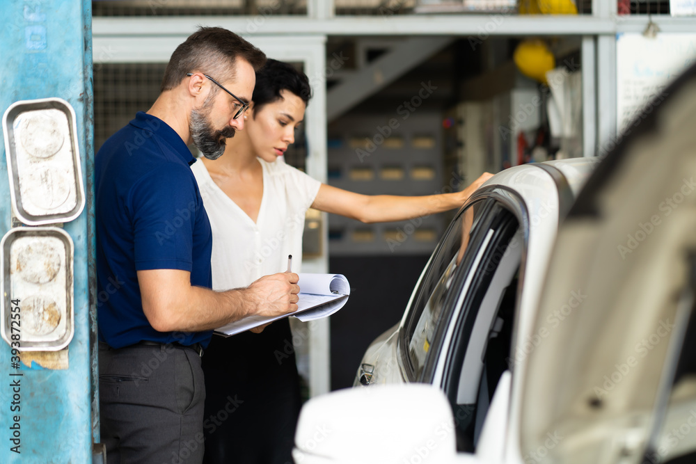 Mechanic man and woman customer check the car condition before delivery ...