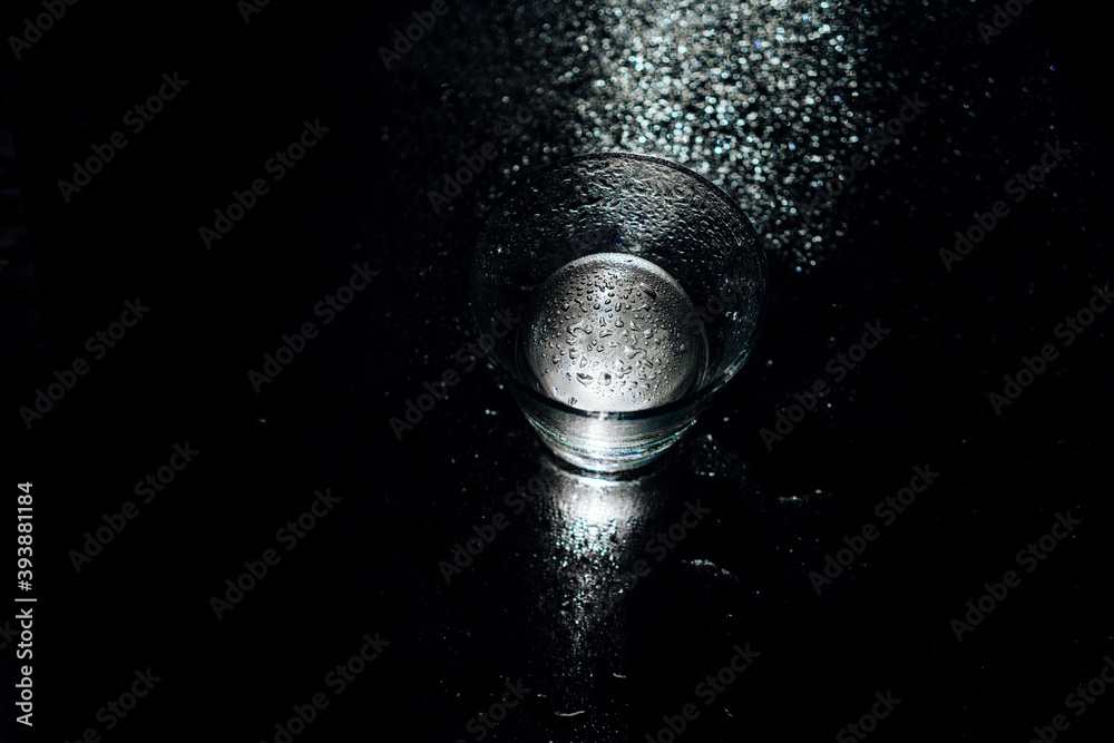 Glass of water on mirror background with reflection in the mirror and ...