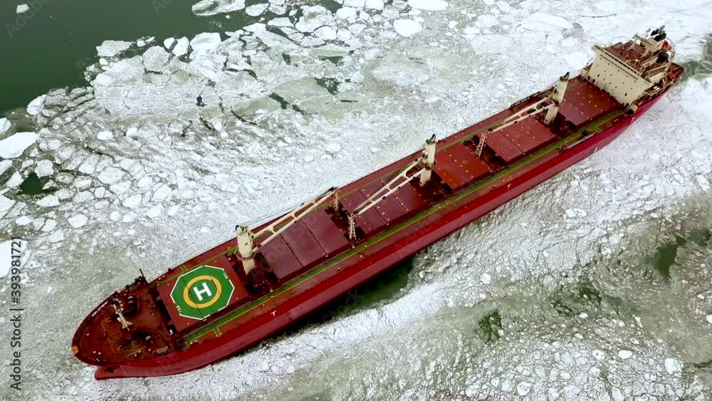 Aerial above epic huge steel ship breaks ice by bow of ship and floats ...