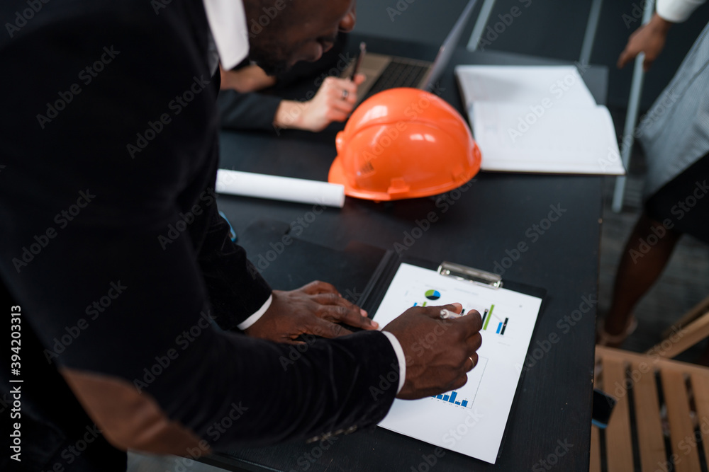 View from above. African American man shows sales report to work ...