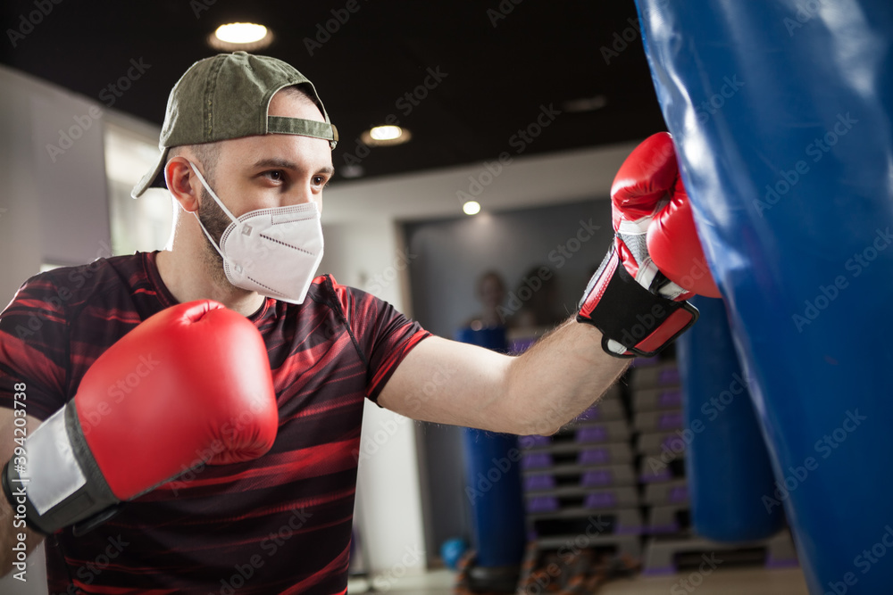 Young caucasian male wearing red boxing gloves & protective face mask ...