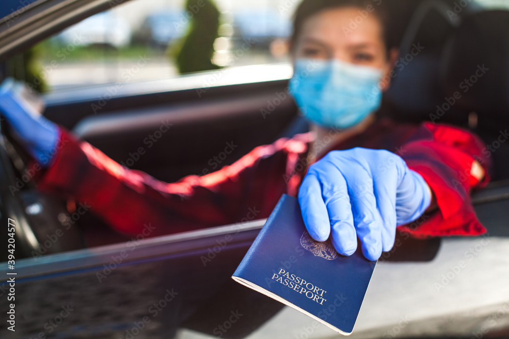Young woman holding blue passport through car window,patrol border ...