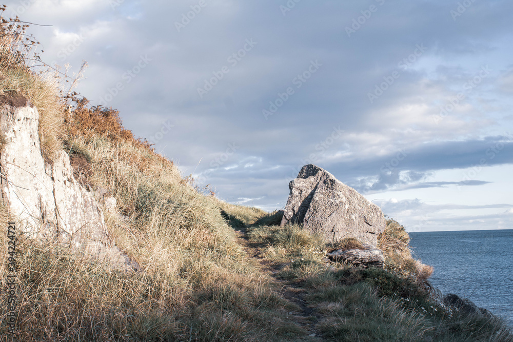 Hiking along the coastal cliffs of West Cork Ireland. Mark and unmarked ...