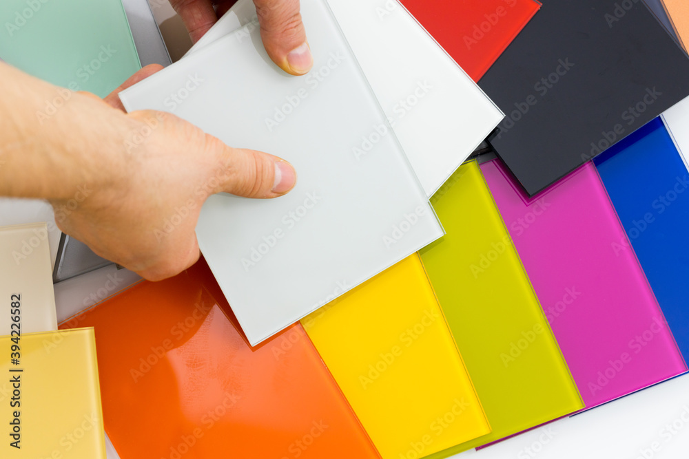 Colored glass for interior finishing. The craftsman shows samples of ...