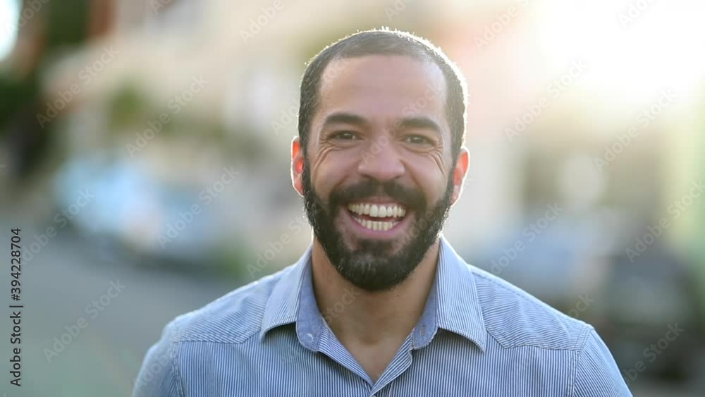 Man smiling and laughing outdoors with lens-flare. Person in 40s smile ...