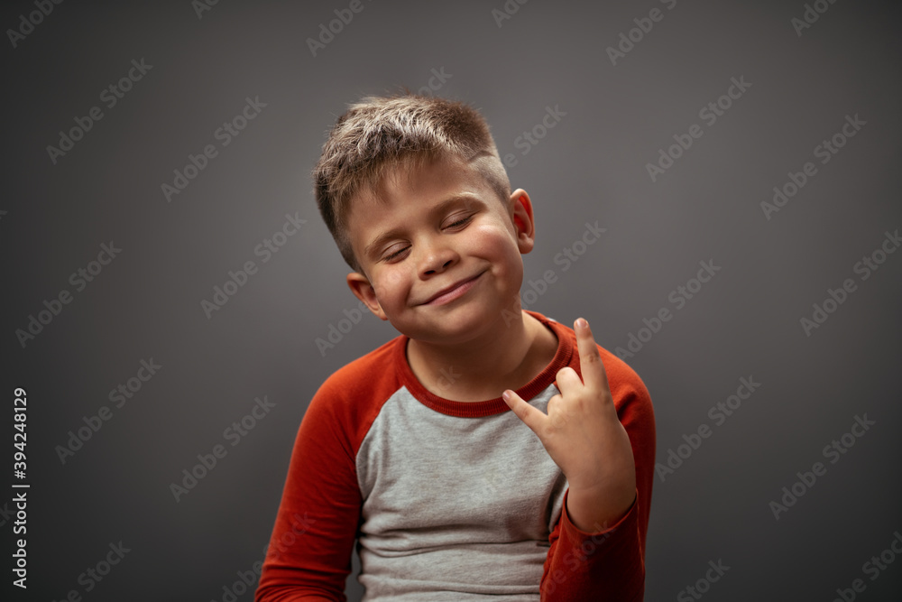 This kid rocks. Fool of satisfied emotions little boy showing ROCK ...