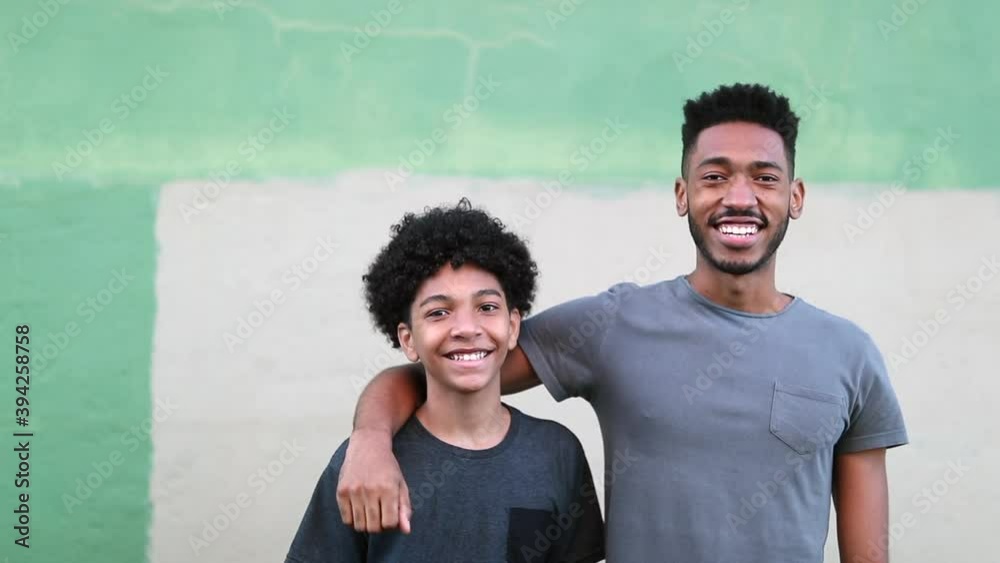 Two brothers hanging together smiling at camera. Young black African ...