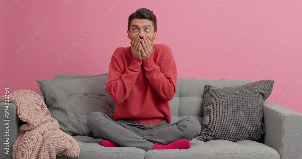 Happy surprised man keeps hands on cheeks and reacts at something ...