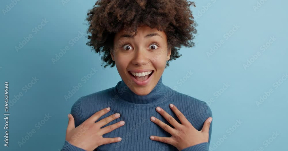 Beautiful young Afro American woman looks with surprised face ...