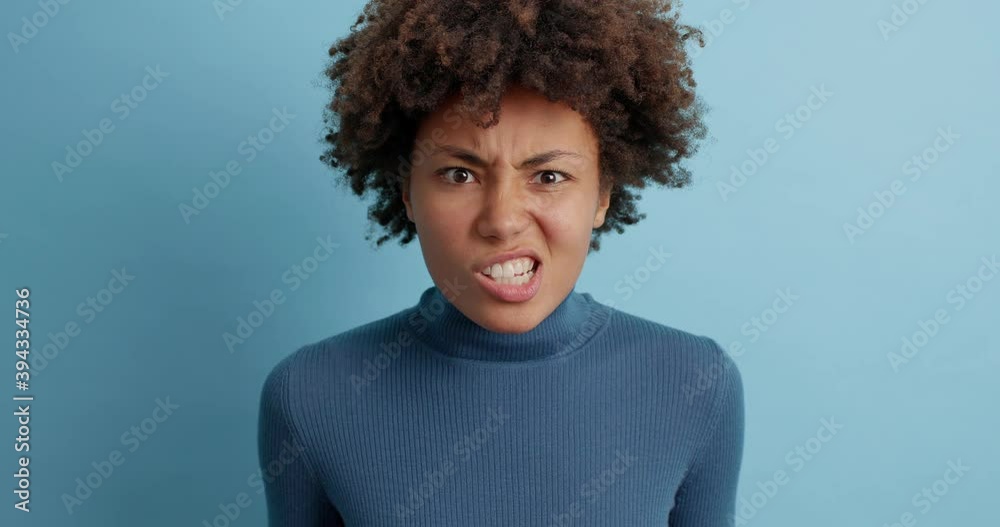 Annoyed dark skinned young woman screams very loudly expresses rage and ...