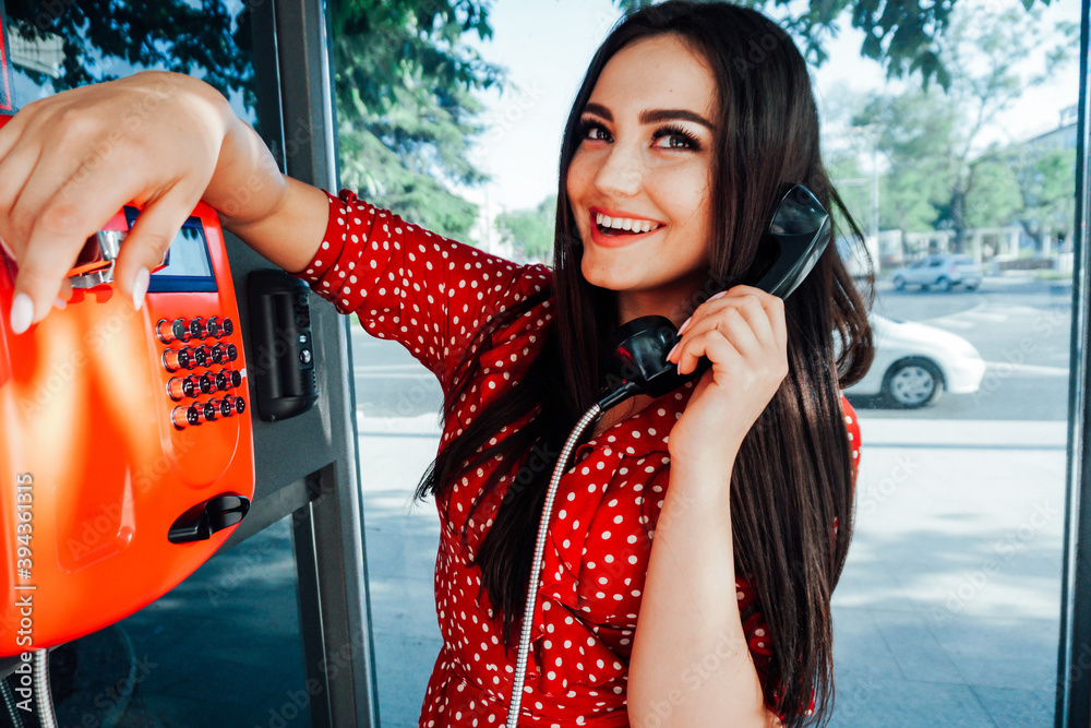 Beautiful brunette woman in red dress talking in a phone booth Stock ...