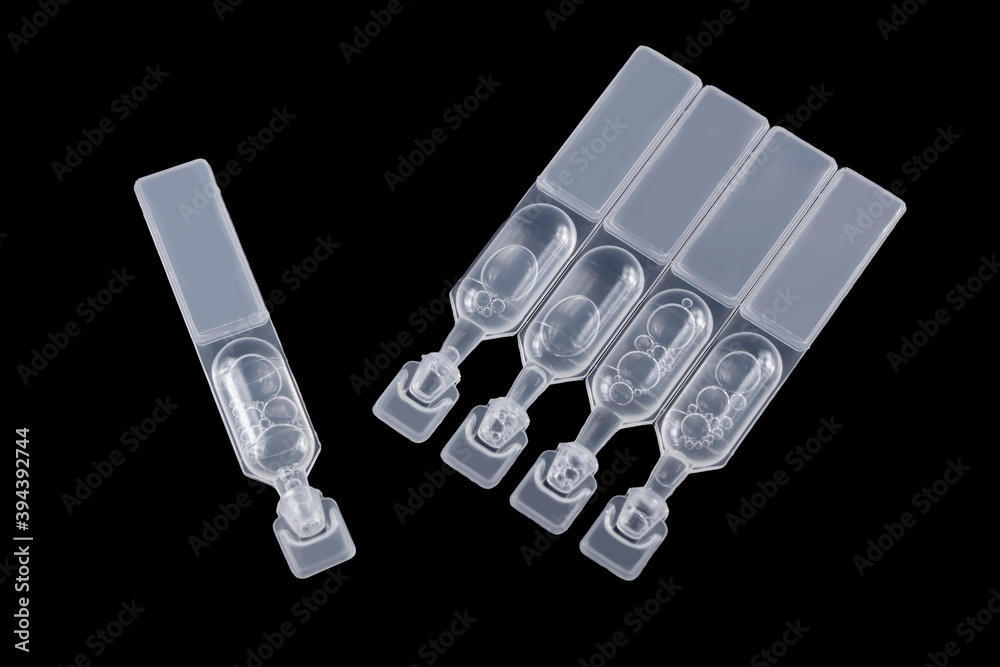 Pack of artificial tear single use containers isolated on black. Eye ...