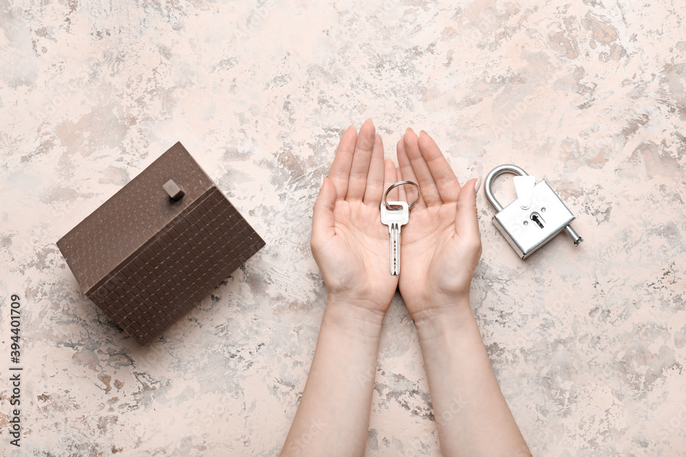 Female hands with key, model of house and padlock on light background ...
