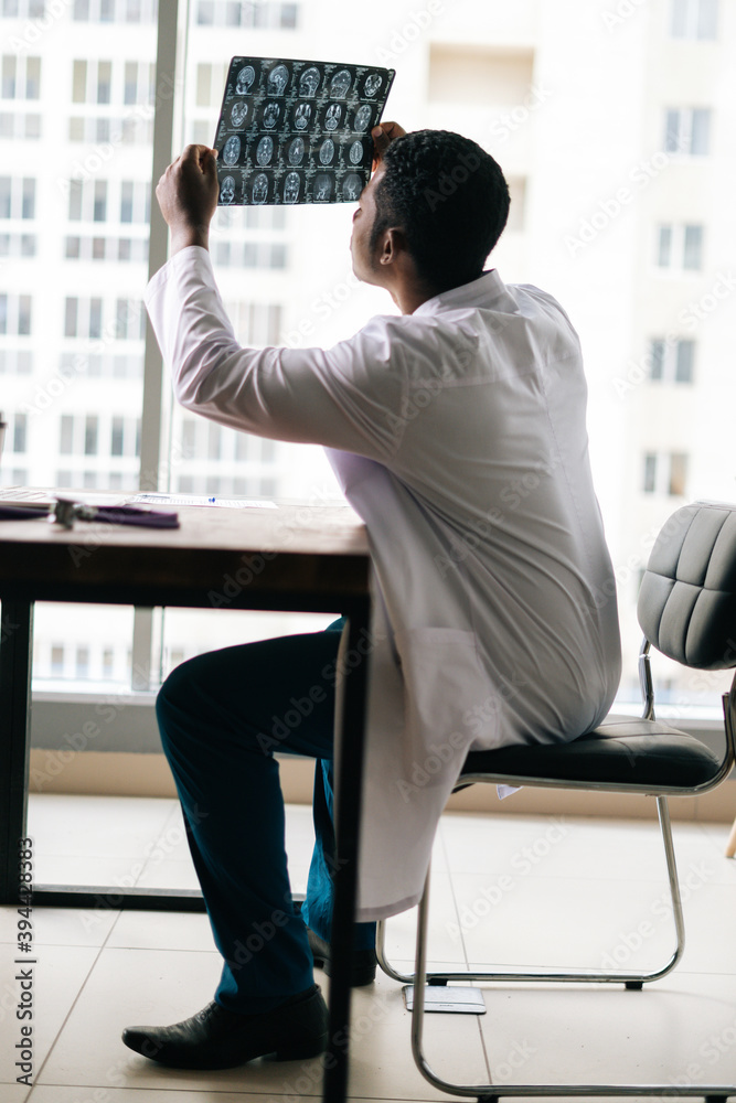 African American black man doctor looking at MRI brain scan image while ...