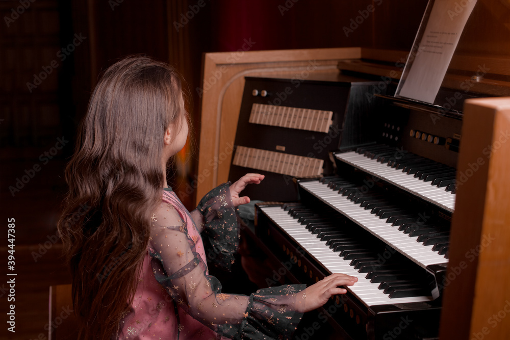 Little girl playing a pipe organ Stock Photo | Adobe Stock