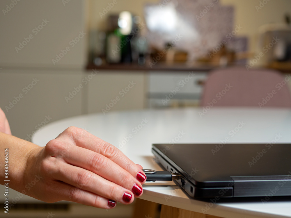 female manicured hand plugging usb, connecting USB flash drive in white ...