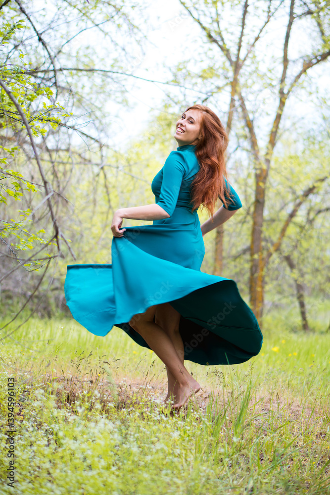 Beautiful bootless woman dance in forest. Barefoot girl in elegant blue ...