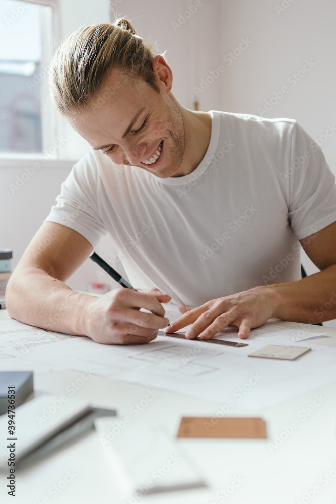 Smiling happy guy creating an architectural drawing Stock Photo | Adobe ...
