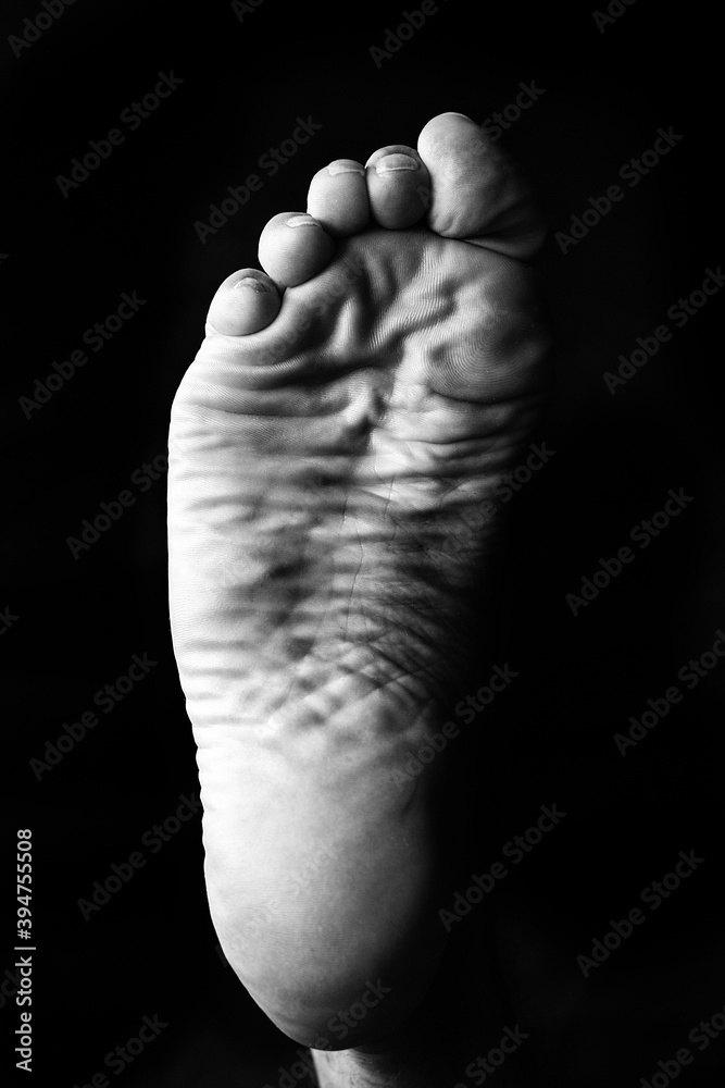 sole of the foot of an adult person wrinkled with the black background ...