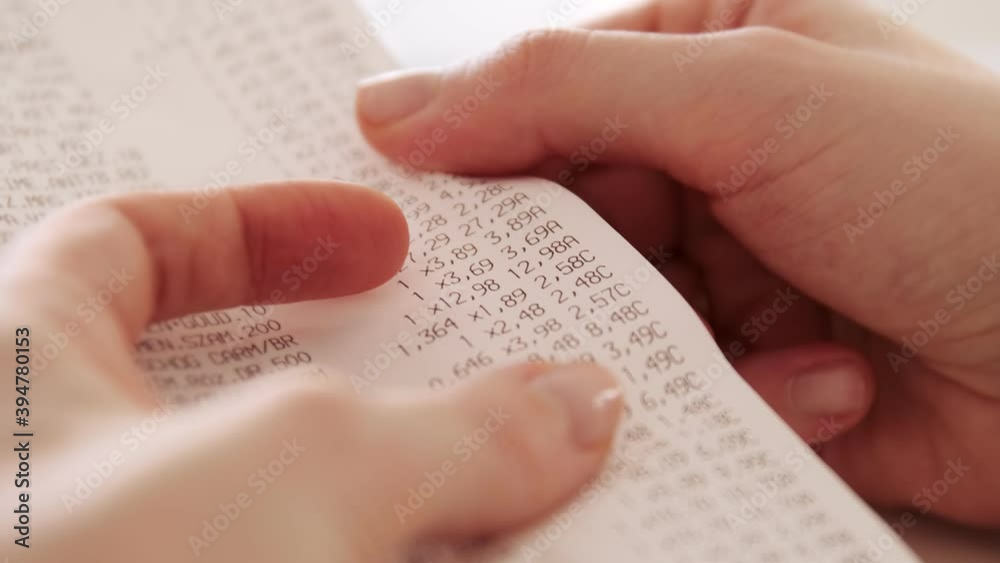 Hands checking grocery receipt or bill after grocery shopping at a ...