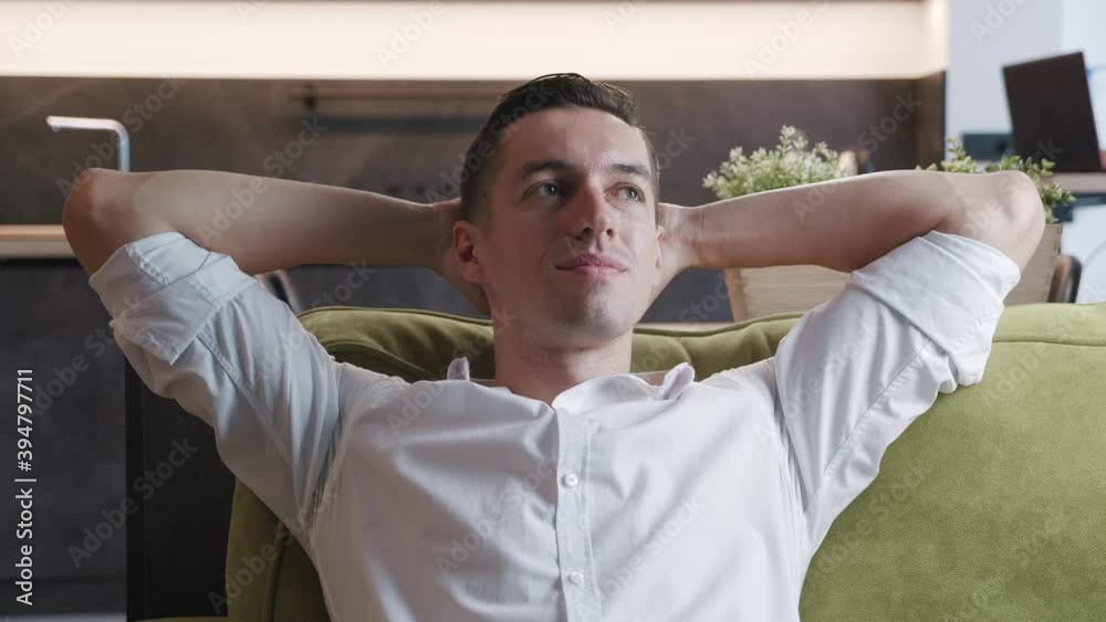 Calm relaxed young man resting on cozy sofa at home. Happy businessman ...