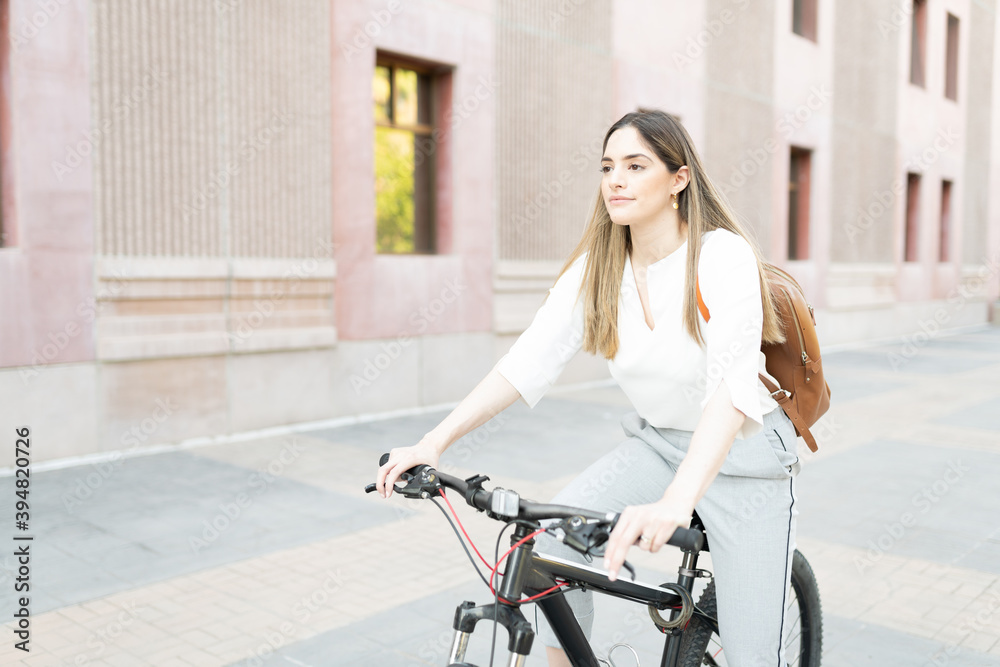 Professional female worker using an eco-friendly bycicle to get to her ...