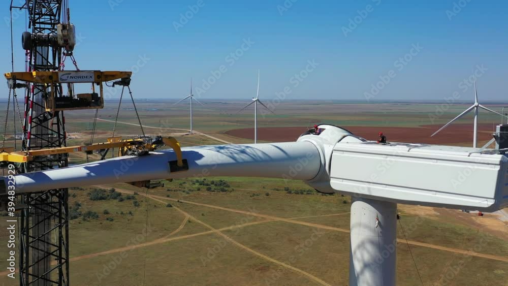 Construction workers are assembling a wind turbine, high altitude work ...