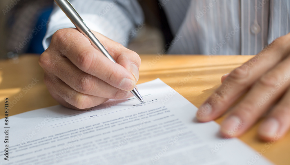 A hand of a man holding a pen signing a letter. Contract . Agreement ...