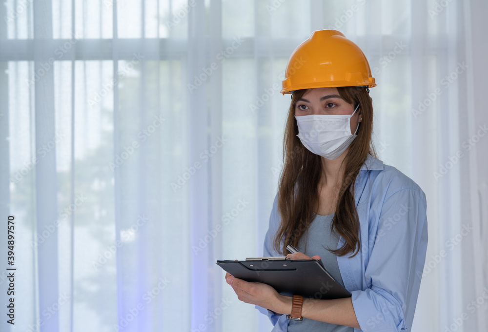 Female Engineer wear face mask with safety yellow helmet standing ...