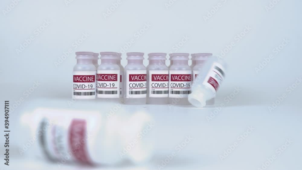 COVID19 vaccination concept. Empty vaccine bottles fall on the table in ...