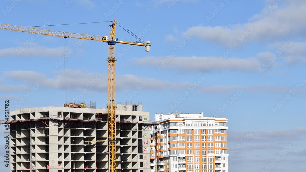 Build crane jib and unfinished skyscraper building with clouds in sky ...