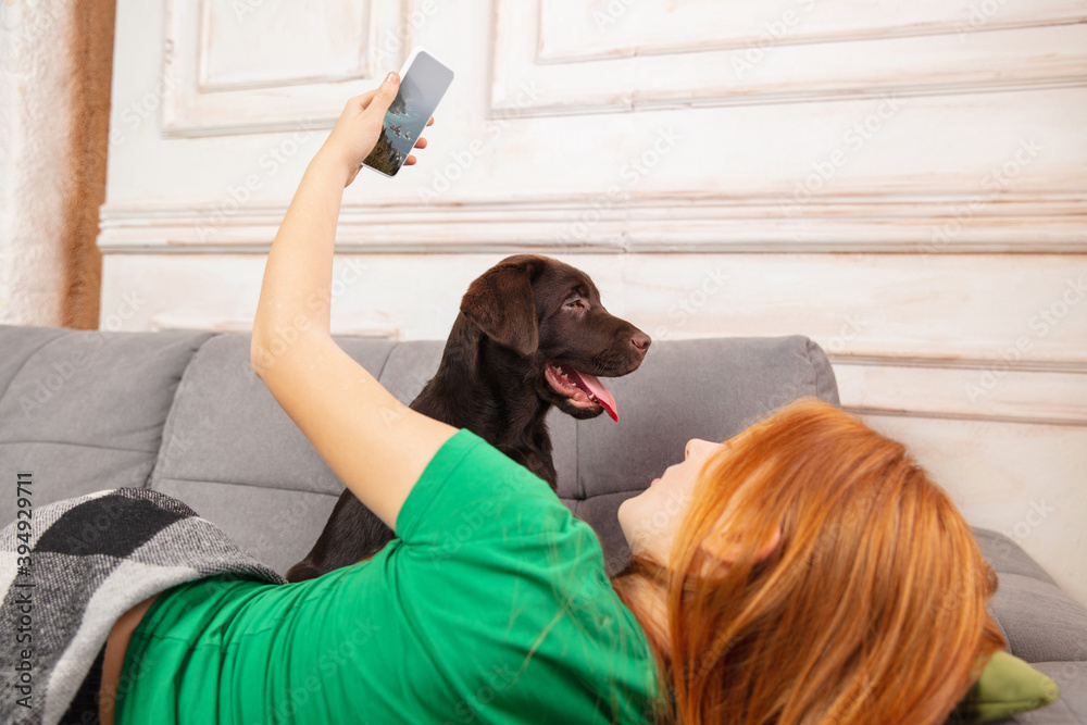Happy Caucasian little girl during video call by phone with her dog ...
