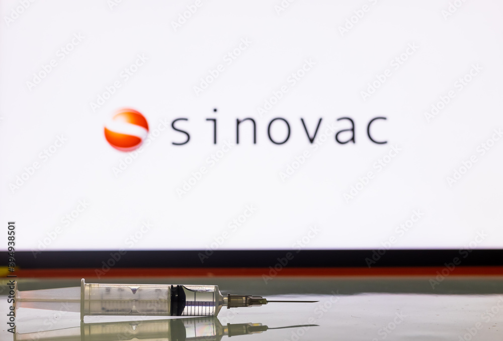 Syringe Injection infront of Sinovac Logo. Sinovac is among many COVID ...