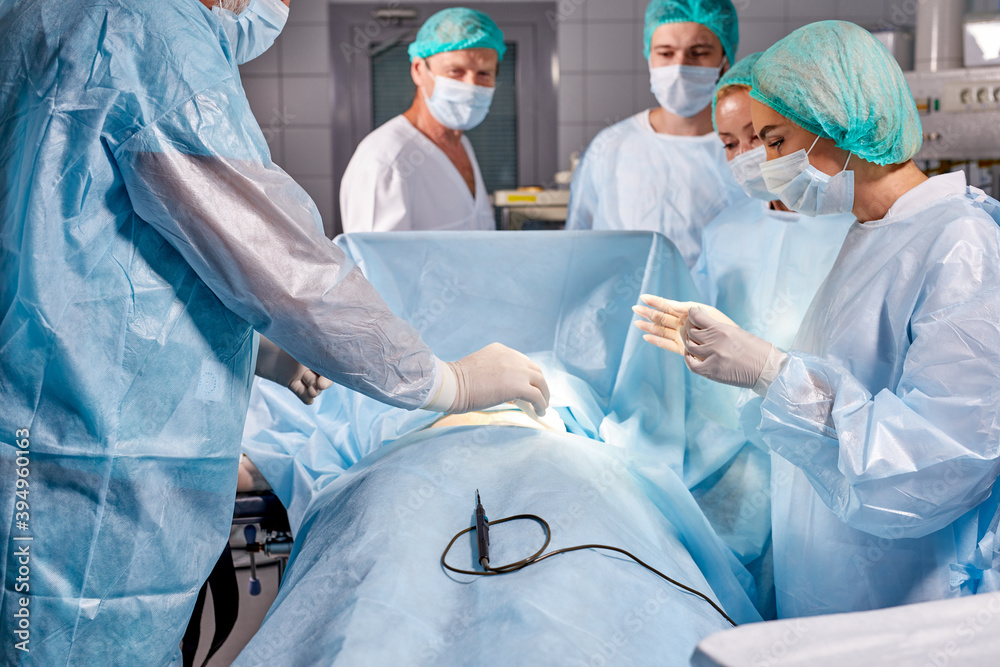 surgery room caucasian team of professional surgeons and nurses working ...