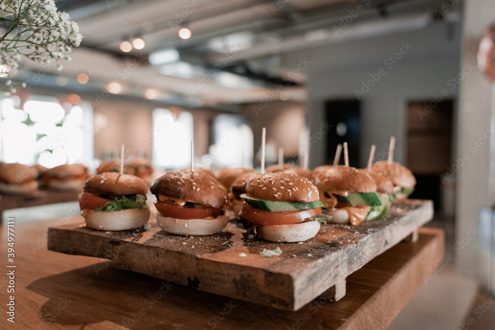 Tasty Burgers on a wooden board, beautifully prepared and well arranged ...
