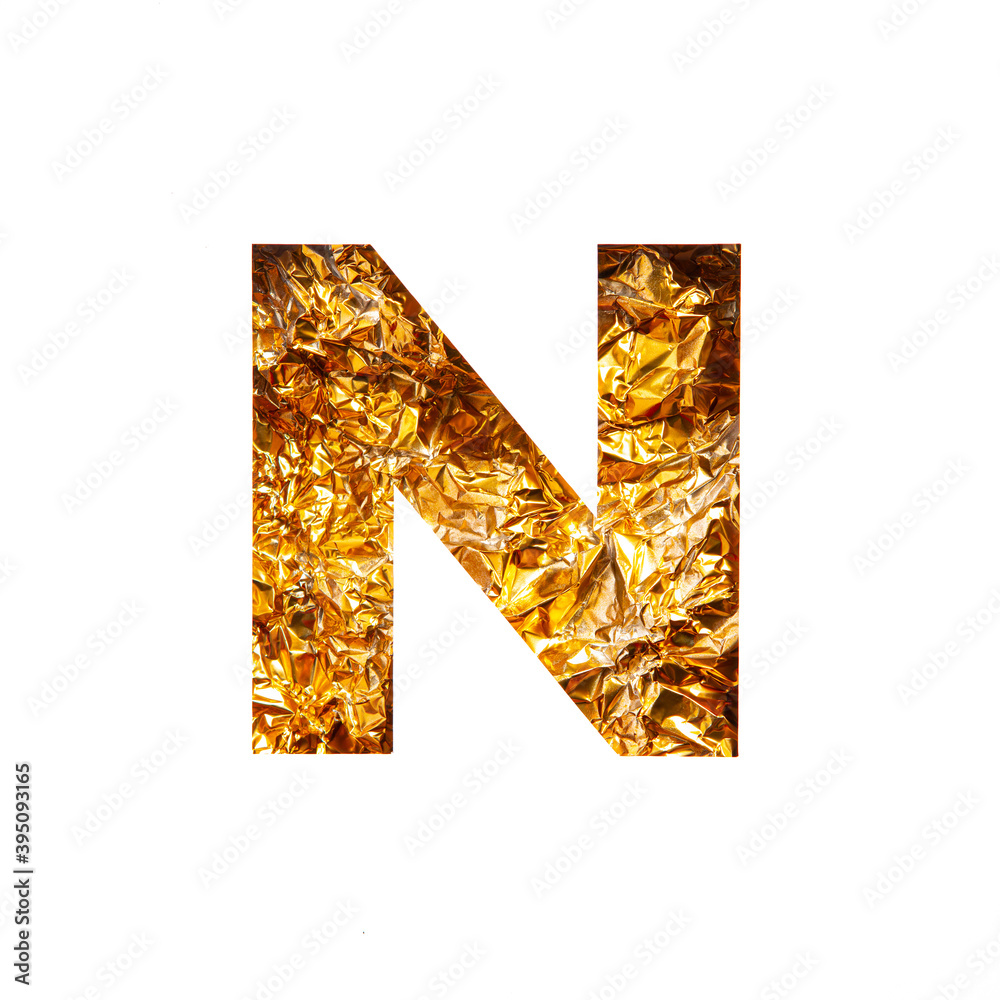 Gold letter N of English alphabet of glittering crumpled foil and paper ...