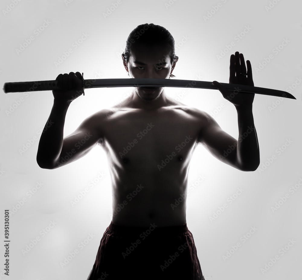 Shirtless Mid Adult Man Holding Sword While Standing Against White ...